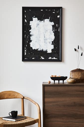 모의 포스터 프레임 갈색 나무 컴모드 안락 의자 및 작은 집 장식이있는 세련된 거실 인테리어 구성 흰색 벽 공간을 복사합니다 템플렛 N 실내에 대한 스톡 사진 및 기타