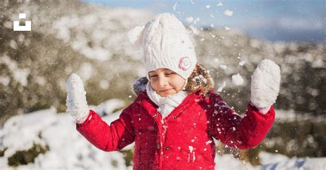 빨간 재킷과 흰색 니트 모자를 쓴 소녀는 낮에 눈 덮인 땅에 서 있다 사진 Unsplash의 무료 자연 이미지