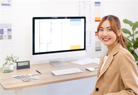 행복한 아시아 여성 인테리어 디자이너가 사무실에 앉아 창의적인 프로젝트를 진행하고 웃고 있다 쾌활한 젊은 여성 건축가의 초상화는
