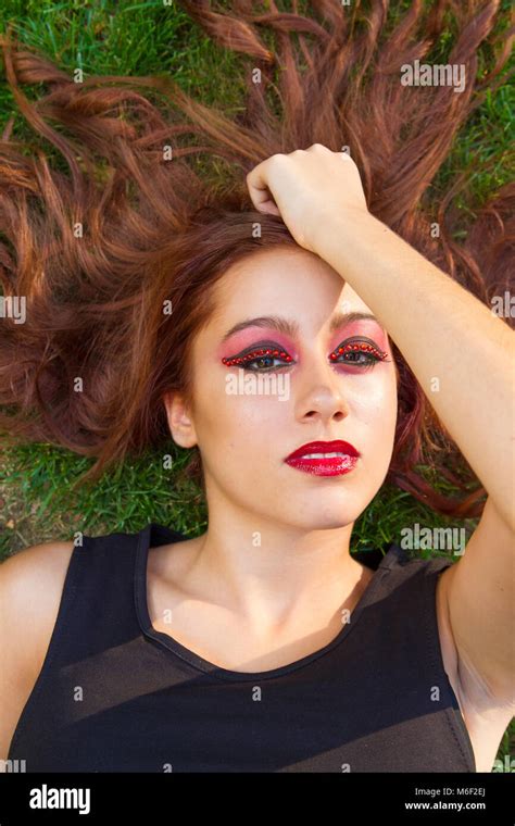 Cute Beautiful Redhead Hispanic Girl Lying On The Grass With Serene And