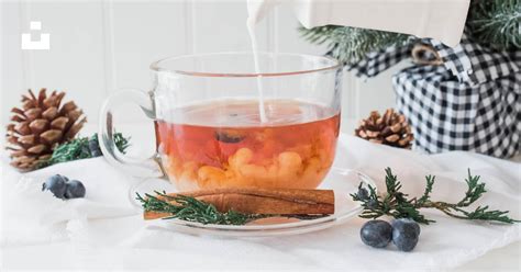 맑은 차 잔에 흰 액체를 붓는 흰색 세라믹 투수를 들고 있는 사람 사진 Unsplash의 무료 음식 이미지