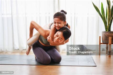 아시아의 젊은 어머니는 집에서 거실에서 요가 매트에 함께 요가 포즈와 운동에 그녀의 딸을 가르치고 딸에 대한 스톡 사진 및 기타 이미지 Istock