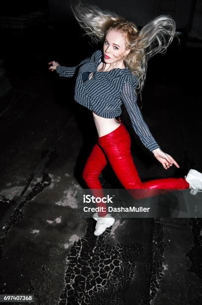 아름 다운 행복 금발의 유럽 숙 녀 밤에 거리에 포즈의 야외 초상화 세련 된 옷 빨간 바지를 입고 만드십시오 그리고 점프 여성 패션입니다 시 밤 생활양식입니다 공간에 복사
