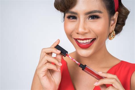 Premium Photo Portrait Of Woman Applying Lipstick Against White