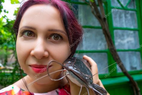 Una Mujer Sonriente Con Un Vestido Rosa Sosteniendo Un Gran Siluro