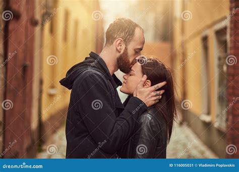 Bearded Man And Brunette Girl Kissing On The Background Of The Old
