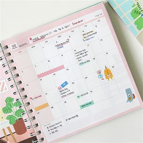 An Open Planner With Stickers On It Next To A Cup Of Coffee And A Plant