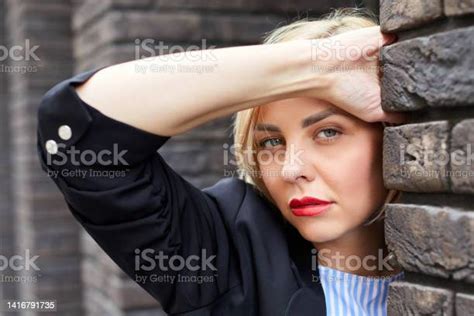 금발의 젊은 여성이 하얀 외벽에 기대어 서서 도시 거리에서 복사 공간을 확보하고 카메라를 바라 봅니다 거리에 대한 스톡 사진 및 기타 이미지 Istock