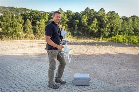 Man An Engineer Pilot A Drone Prepares Air Device For Take Off For Testing And Filming A