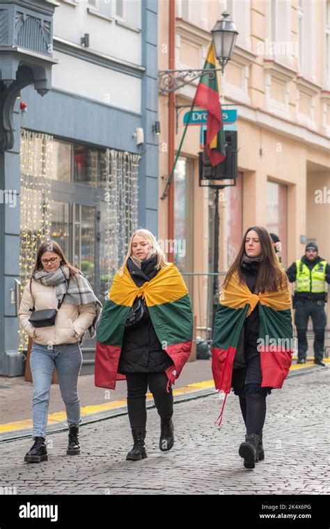 Lithuanian Girls Walking In Vilnius Old Town With Flags Of Lithuania