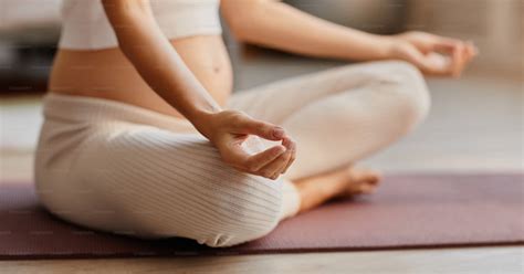 젊은 임산부가 운동 매트에 앉아 명상을 하는 동안 클로즈업한다 사진 Unsplash의 명상 이미지