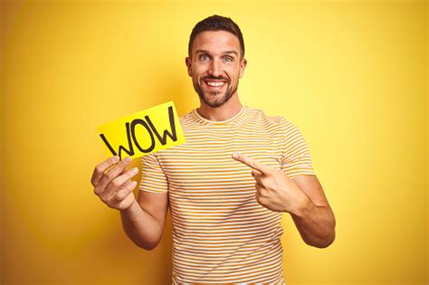 젊은 남자 들고 와우 텍스트 배너 위에 노란색 고립 된 배경 매우 행복 가리키는 손과 손가락 가리키기에 대한 스톡 사진 및 기타 이미지 Istock