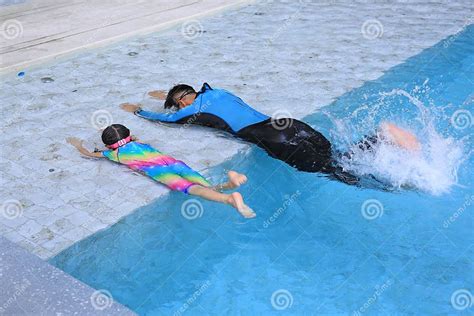 Professora Ensinando Menininha Asiática Aprendendo A Nadar Na Piscina