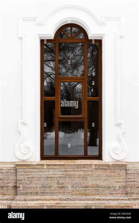 Classical Window With Arch And Decorative Elements In White Stone Wall