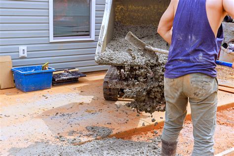 건설 노동자가 집 밖의 화창한 날 주거용 마당에서 안뜰 확장을 위해 콘크리트를 붓고 있습니다 45 49세에 대한 스톡 사진 및 기타 이미지 Istock