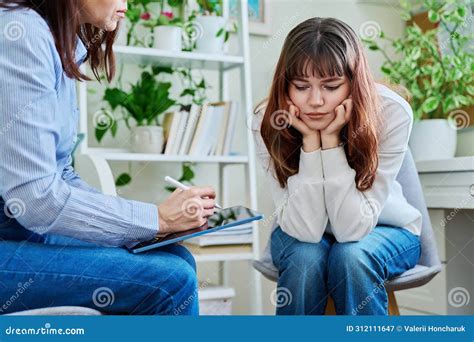Sad Serious Teenage Girl At Session In Office Of Mental Counselor