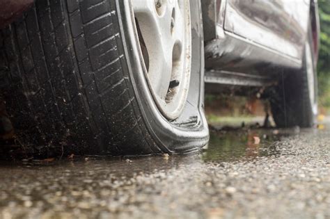 Llanta De Coche Desinflada En Día Lluvioso Foto Premium