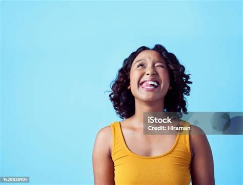 파란 배경의 이빨 위에 혀를 내밀고 코믹하고 재미있는 얼굴을 가진 행복한 흑인 여성 재미 미친 소녀 아름다움과 여성의 독립에 대해 흥분 미소로 삶의 축하 라틴 아메리카