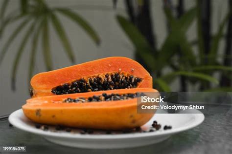 흰 접시에 씨앗과 배경에 녹색 식물과 잘 익은 파파야의 절반 달콤한 파파야 조각 반으로 자른 파파야 건강한 이국적인 과일 채식 음식 0명에 대한 스톡 사진 및 기타 이미지