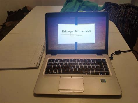 A Plugged In Laptop On A White Table With A Presentation Slide On Full Download Scientific