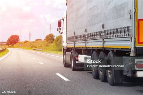 세미 트레일러가 달린 트럭은 여름에 태양을 배경으로 고속도로를 따라 건설 자재를 운반합니다 트럭 운전사로 일하는 개념 텍스트 공간 복사 0명에 대한 스톡 사진 및 기타