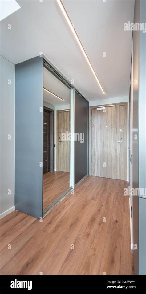 A Contemporary Hallway Featuring Wooden Flooring Walls With Neutral