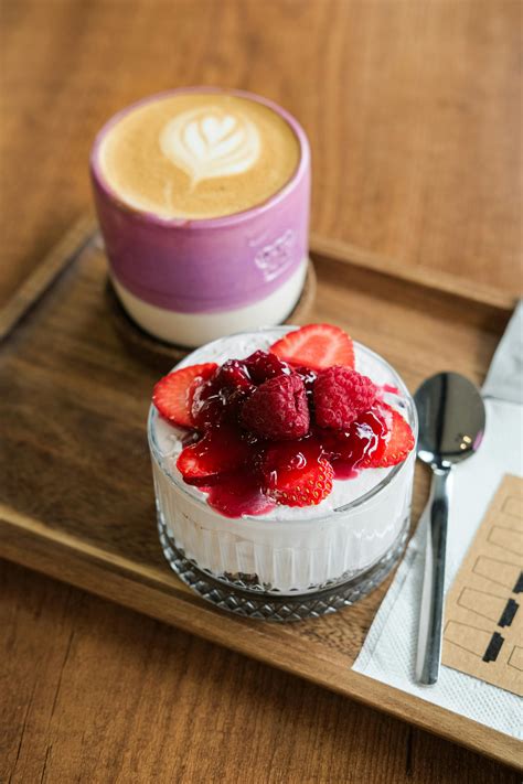 과일 토핑 나무 쟁반 나무 질감 달콤한 대접 디저트 딸기 딸기 조각 라떼 아트 라즈베리 라즈베리 장식 맛있는 미식가 베리 디저트 브런치 생생한 색상