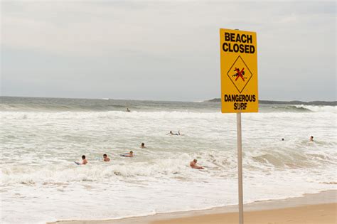 해변에서 해변 폐쇄 표지판 경고에도 불구하고 사람들은 여전히 수영과 서핑을하고 있습니다 감시에 대한 스톡 사진 및 기타 이미지 감시 개념 경계 표지 Istock