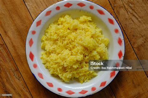 나시 쿠닝은 강황 코코넛 밀크 향신료로 만든 인도네시아의 노란 쌀입니다 쇠고기 치실 크래커 얇게 썬 오믈렛 튀긴 땅콩 바나나 잎에 튀긴 템페와 함께 제공됩니다 길거리 음식