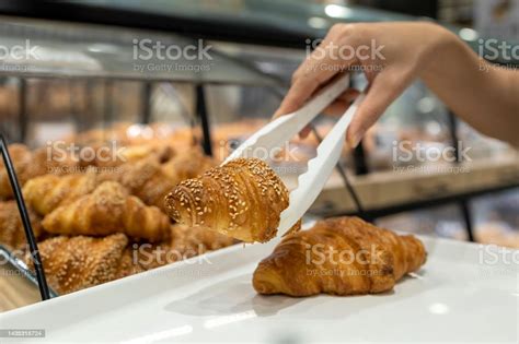 빵집 가게에서 크로와상을 사는 여성이 쟁반과 서비스 집게를 들고 선택하는 경우 고름에 대한 스톡 사진 및 기타 이미지 고름 곡초류 다양 Istock