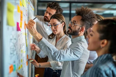 Premium Photo A Diverse Group Of Individuals Gathered Around A Whiteboard Engaged In A