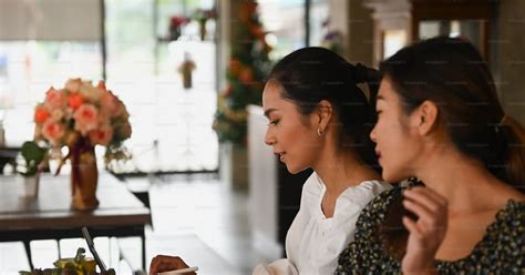 두 명의 여성 프리랜서가 새로운 기회에 대해 이야기하고 사무실 책상에서 컴퓨터 태블릿으로 작업하고 있습니다 사진