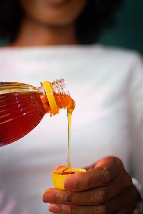 노란색 배경의 나무 국자에서 꿀이 흘러내리는 모습 · 무료 스톡 사진