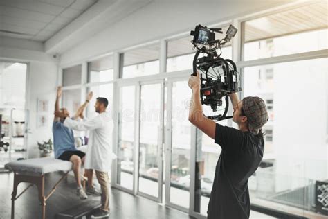 Putting It Up High Behind The Scenes Shot Of A Camera Operator