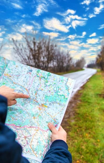 Premium Photo A Man Looks At A Map On The Road Selective Focus