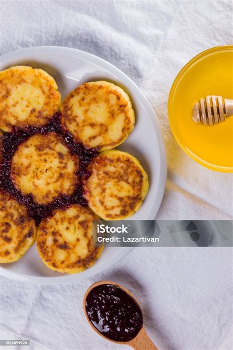 코 티 지 치즈는 흰색 냅킨에 팬케이크 전통적인 우크라이나 접시잼 나무 배경에 Syrniki 벌 꿀과 흰 접시에 코 티 지 치즈의 팬케이크 건강에 좋은 음식 0명에 대한