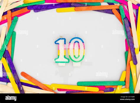 Number 10 Shape Birthday Candles In A Colorful Popsicle Sticks Frame Border On White Background