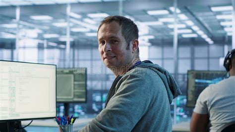Portrait Of Smiling Engineer Inspecting Server Rows In Data Center