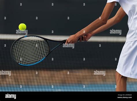 Male Tennis Player Hitting Backhand By Net On The Tennis Court Stock