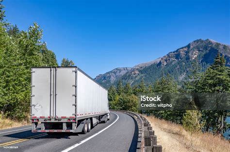 컬럼비아 협곡의 회전 산악 도로에서 달리는 드라이 밴 세미 트레일러에서화물을 운반하는 장거리 운송 대형 리그 화이트 세미 트럭 트럭에 대한 스톡 사진 및 기타 이미지