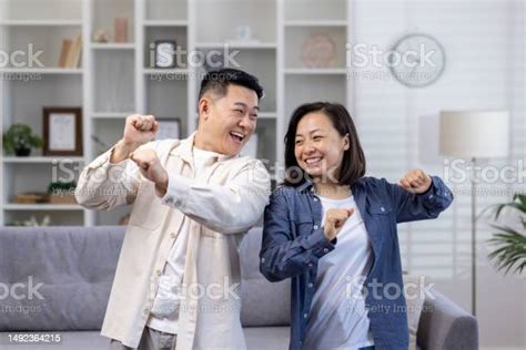 행복한 아시아 커플 남자와 여자는 거실에서 낮에 집에서 함께 춤을 추고 행복한 날과 결혼 기념일을 축하하는 행복한 젊은 가족 춤에 대한 스톡 사진 및 기타 이미지 Istock