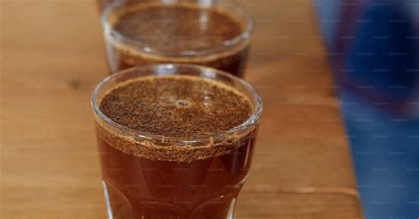 유리 컵에 갓 내린 커피 냄새를 맡고 숟가락을 사용하여 바로스타에 대한 커피 커핑 테스트에서 커피 맛과 풍미를 검사하는 남자의 초상화 사진 Unsplash의 사람 이미지