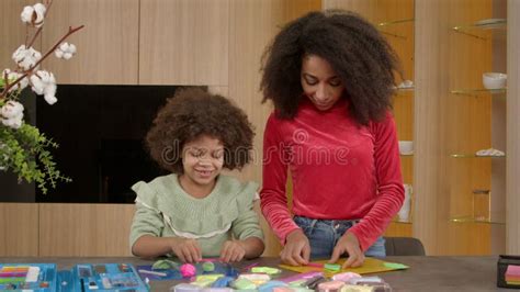 Cute School Age African American Girl And Mother Molding From Colorful
