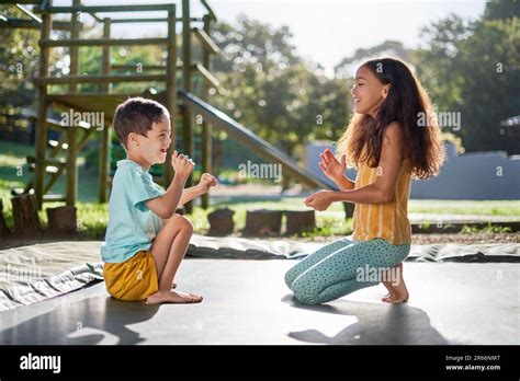 Happy Brother And Sister Playing Clapping Game On Sunny Trampoline Stock Photo Alamy