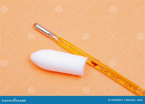 Thermometer And Suppository Medication On Orange Rectal Drug Administration Stock Image