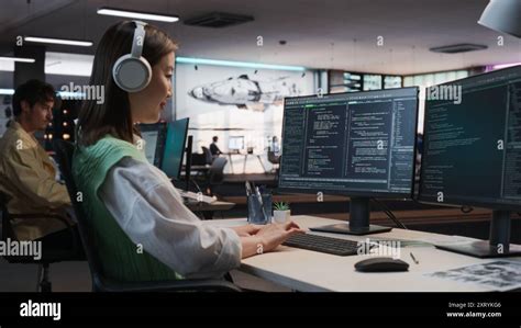 Female Asian Game Programmer Coding On Desktop Computer In Game