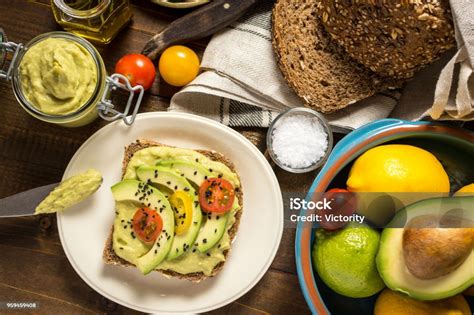 신선한 아보카도 확산 아보카도 소스 그리고 체리 토마토와 검은 참 깨 빵 한 조각에 조각 건강 한 아침 식사 개념입니다 0명에