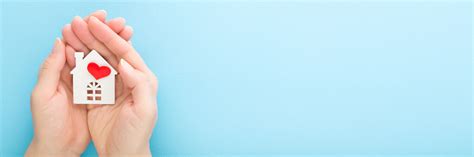 밝은 파란색 테이블 배경에 젊은 성인 여성 손바닥에 밝은 빨간 마음을 가진 백악관 파스텔 색상 근접 촬영 관점 샷 와이드 배너