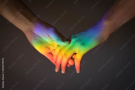 Two Women Holding Hands Illuminated With The Light Of The Lgbt Rainbow Flag Gay Pride Concept