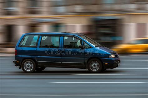 Side View Rolling Shot Of Old Mpv Car In Motion Citroen Jumpy Driving Along The Street In City Side View Rolling Shot Of Old Mpv Car In Motion Citroen Jumpy Driving Along The Street In City